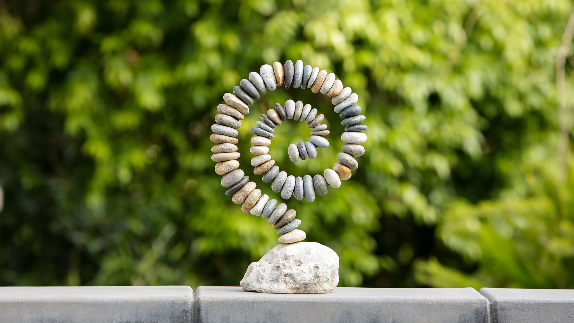 Beach Pebble Spiral Sculpture on White Stone Base | Awesome Stones