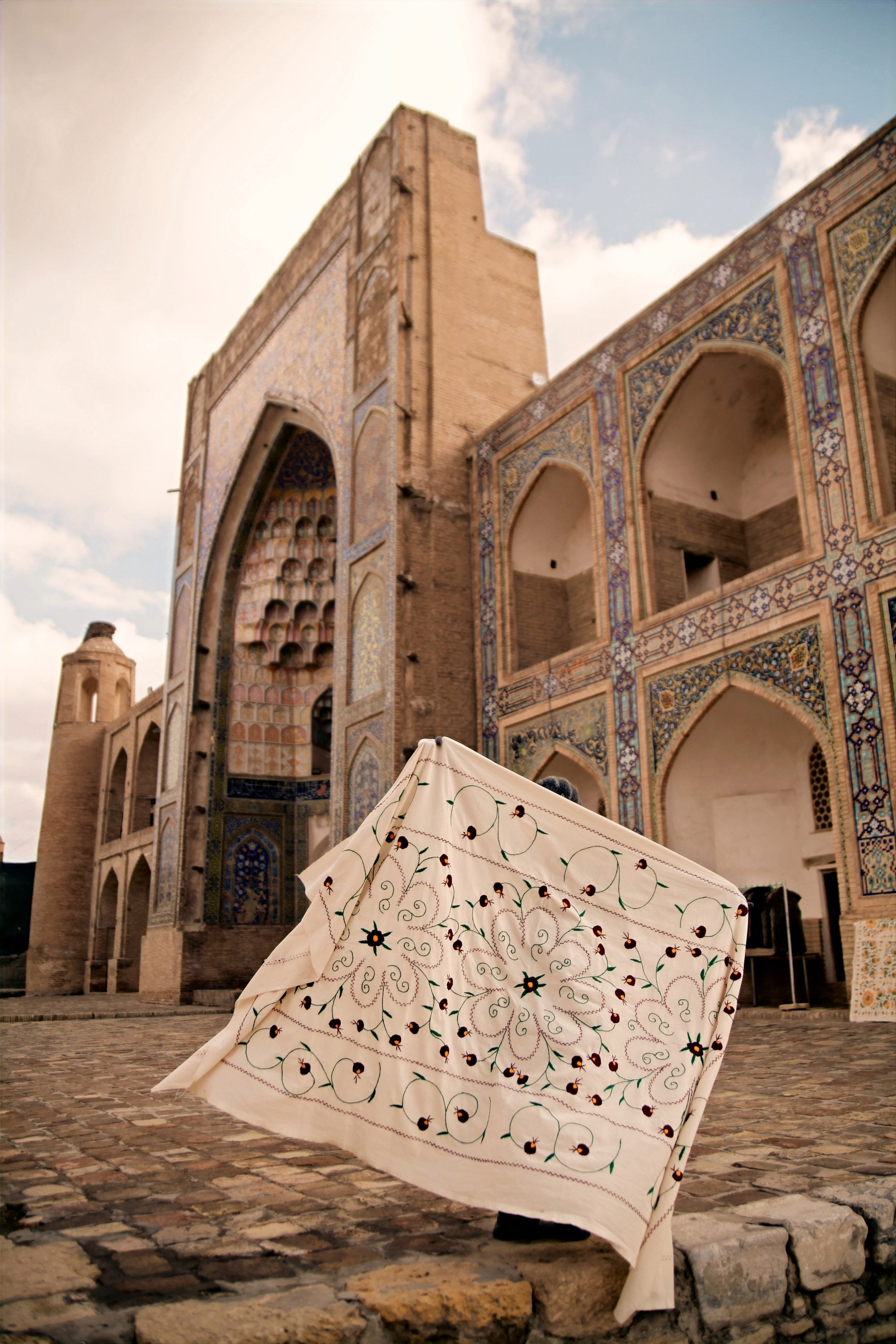 A "suzani" seller at the gate of the Abdulaziz Khan Madrasah