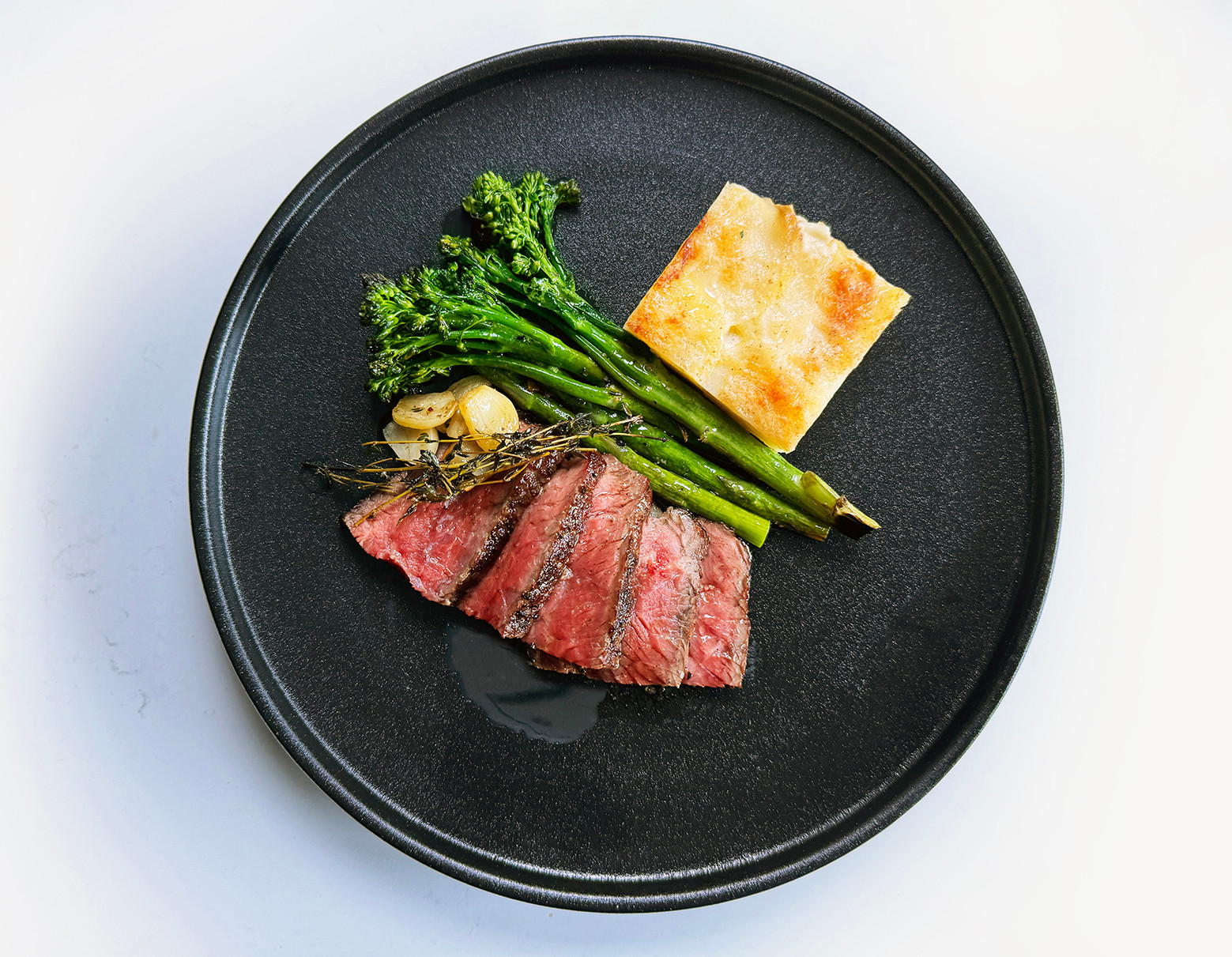 Tomahawk caveman style met gratin, bimi en gepofte knoflook