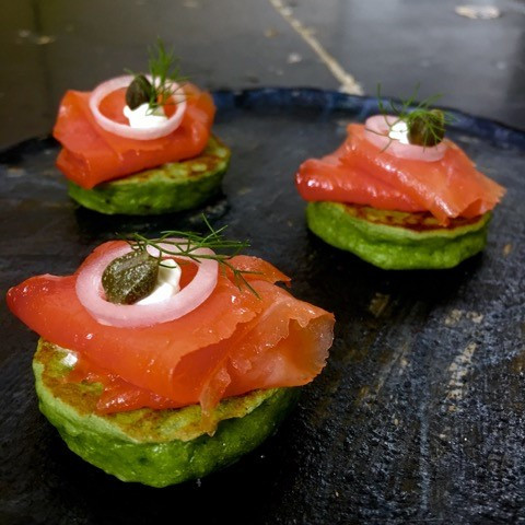 Hand sliced smoked salmon on a green pea blini with wasabi creme ...