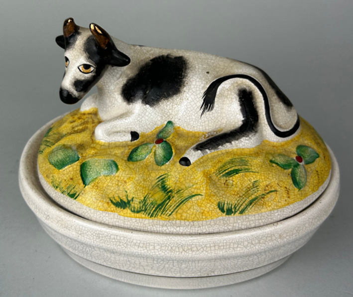 A CERAMIC COVERED COW DISH
