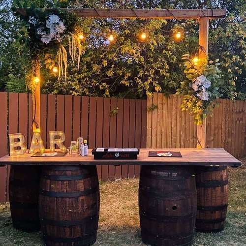 Rustic Barrel Bar Arch with Lights, Flowers & Bar Sign | Nick's Rental