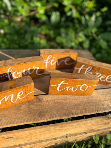 Dark wood cursive table numbers | eventsbydesign