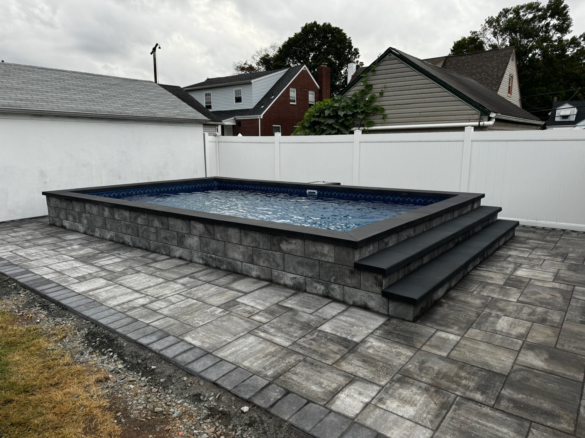Sleek Black-Capped Semi Inground Pool with Matching Step System | Zee Pools