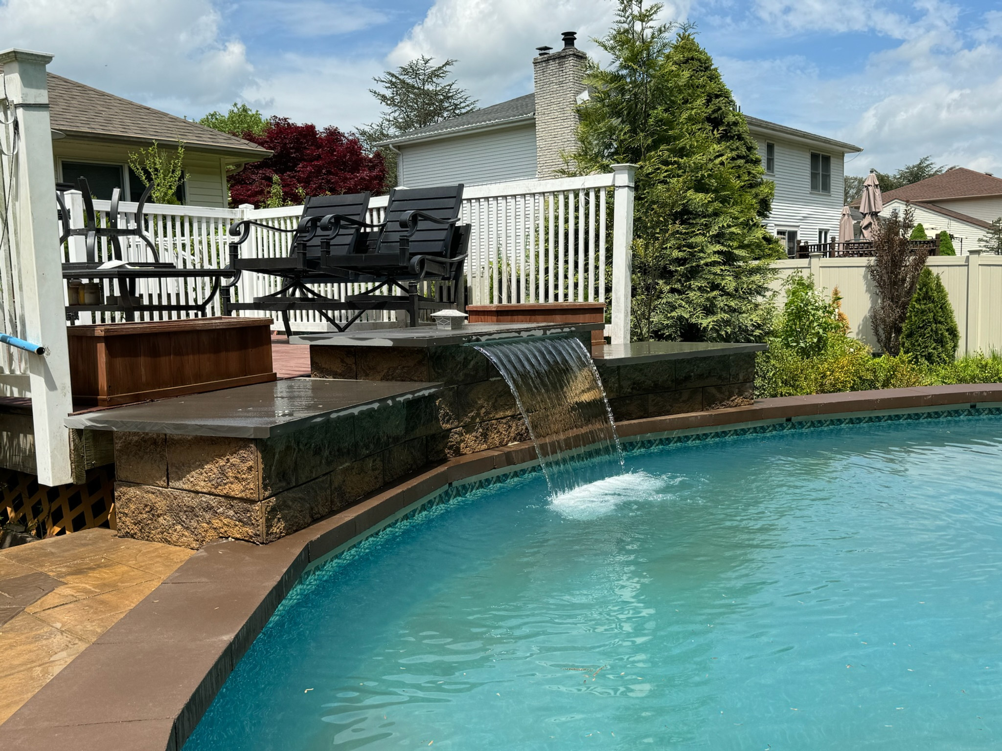 Curved Pool with Raised Deck and Spillover Feature | Zee Pools