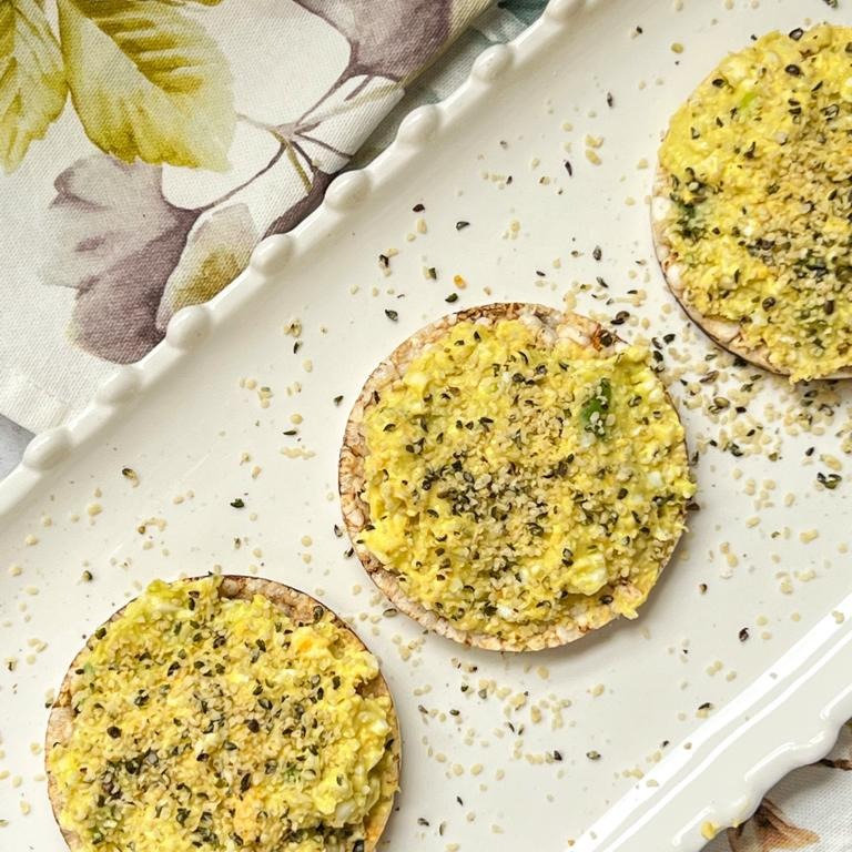 Galleta de arroz con palta, huevo duro y hemp hearts