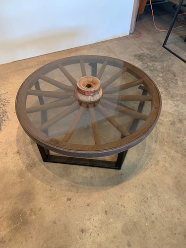 Antique Wagon Wheel coffee table with custom cut glass and steel base | liveedgewooddesigns